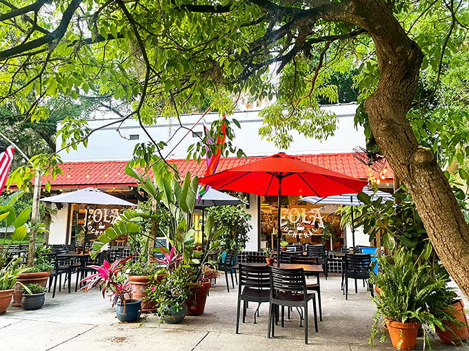 A leafy oasis in urban Orlando, Eola General's inviting patio beckons with red umbrellas and lush greenery&mdash;neighborhood paradise found!