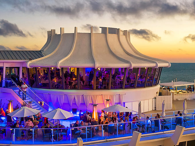 The crown-shaped rooftop of Spinners glows with purple ambiance as sunset paints the sky, promising diners a royal experience above St. Pete Beach.