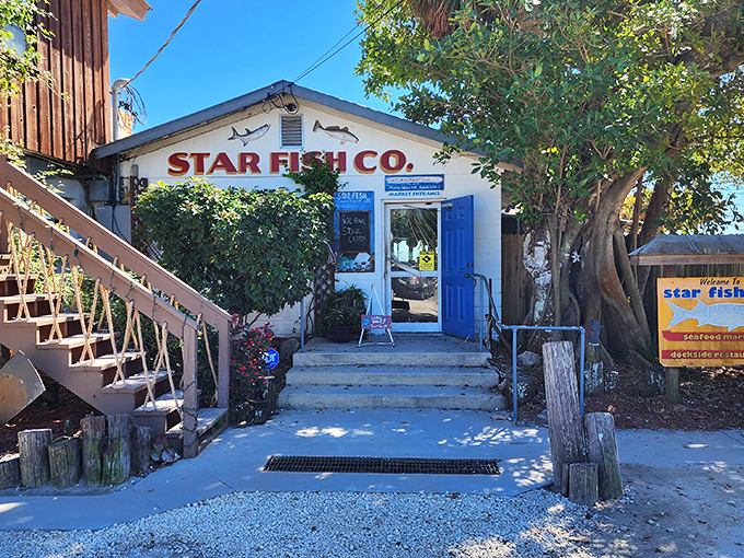 The charming entrance to Star Fish Company beckons with its classic white walls and bright blue door&mdash;Florida's seafood paradise awaits!