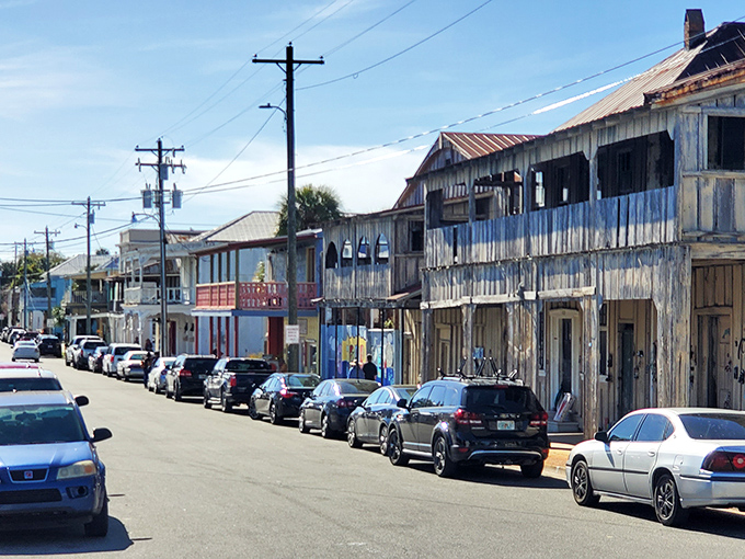 Weathered storefronts wear their age like badges of honor, each paint chip a testament to surviving Florida's moods.