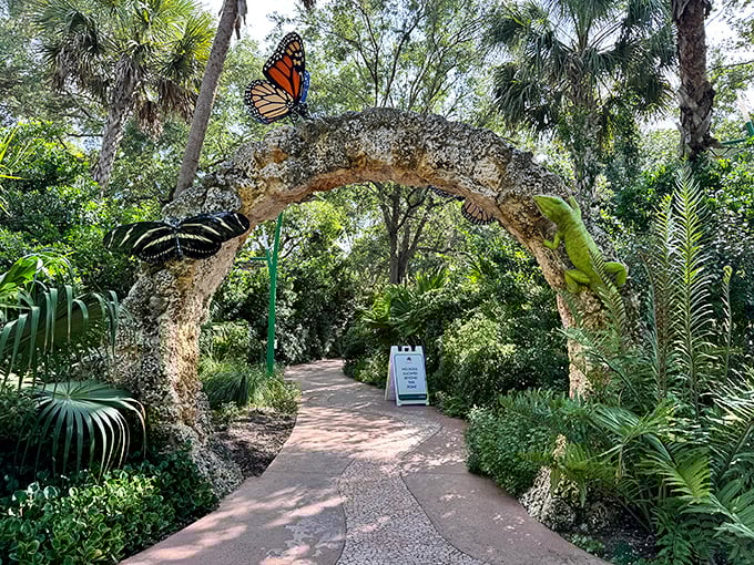 Whimsical stone archways adorned with butterfly sculptures welcome visitors to Pinecrest Gardens' botanical wonderland.