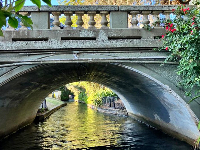 Engineering meets artistry at this century-old stone bridge, its graceful arch reflected perfectly in the still waters below.