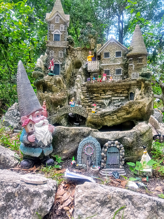 Elaborate fairy castles rise from natural stone formations, populated by tiny figures going about their mysterious fairy business.