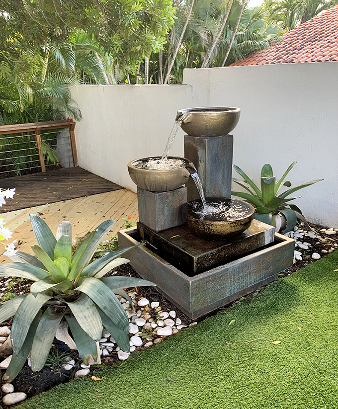 Tranquility flows! This three-tiered fountain surrounded by lush plants creates a peaceful soundtrack for outdoor sipping and savoring.