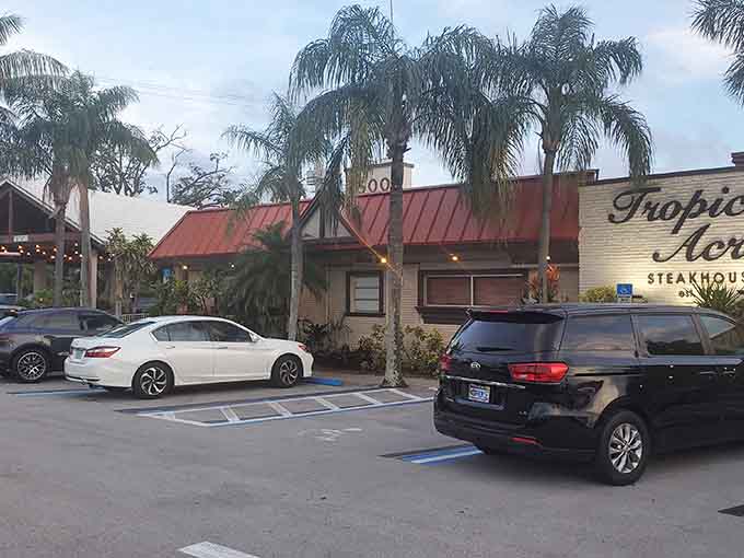 The parking lot and tropical landscaping hint at the classic steakhouse experience waiting inside this unassuming building.