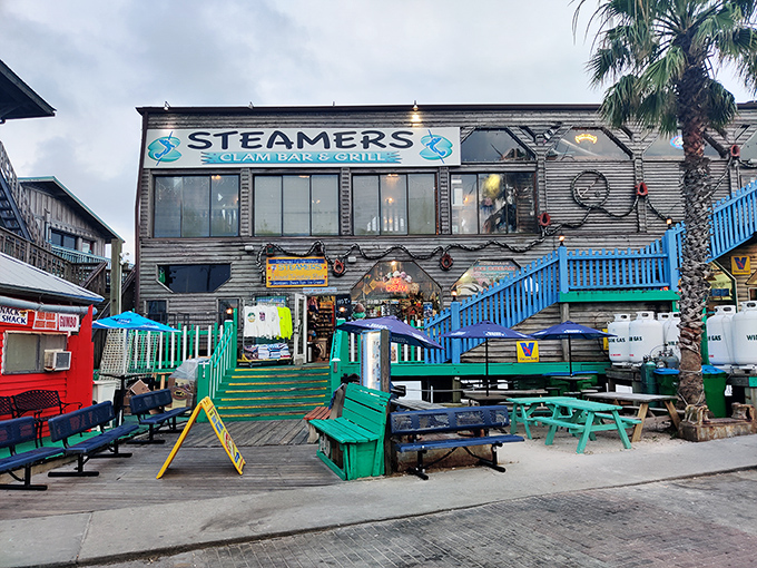 Steamers sits over the water like it grew there naturally, colorful tables promising meals with million-dollar views.