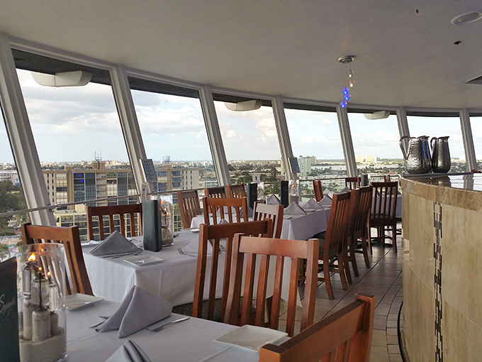 Tables arranged for maximum view appreciation, where white tablecloths signal "special occasion" without whispering "stuffy dress code required."