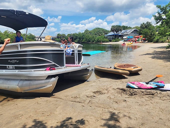 A pontoon boat waits patiently at the shore's edge, ready to transform ordinary people into temporary captains of their own aquatic adventures.