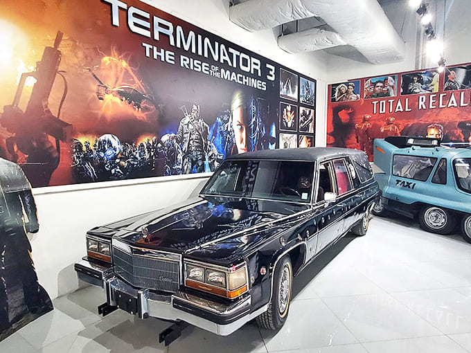 Even the Grim Reaper travels in style &ndash; this sleek 1989 Cadillac hearse combines luxury with macabre purpose under the watchful eye of movie monsters.