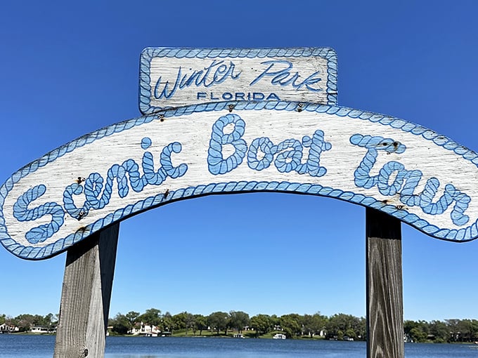 The iconic blue and white sign welcomes visitors to Winter Park's Scenic Boat Tour, promising aquatic adventures just beyond the dock.