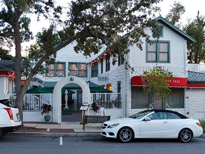 The charming white exterior of 1921 beckons with its historic character and twinkling string lights &ndash; Florida's culinary time machine awaits.