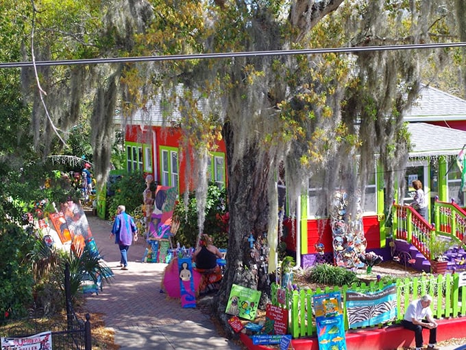 Spanish moss drapes over the vibrant art market courtyard, where visitors browse treasures under Florida's generous sunshine.