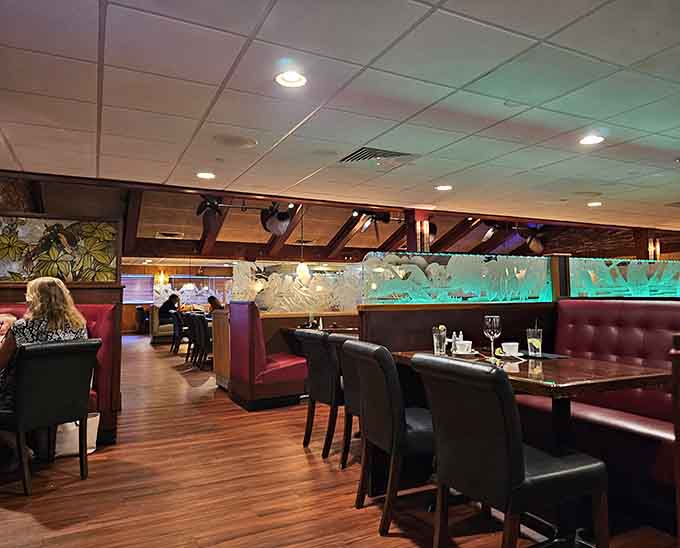 Burgundy booths and exposed beams create that timeless steakhouse atmosphere where every meal feels like a special occasion.