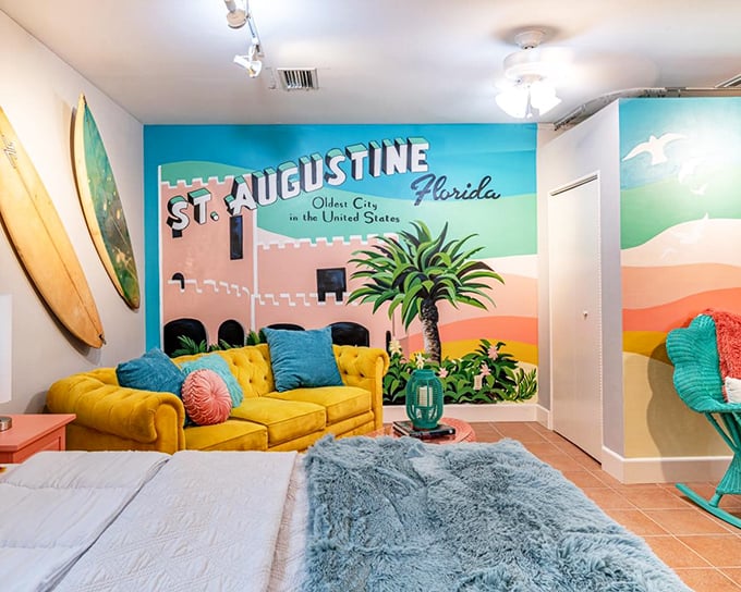 This vibrant bedroom brings St. Augustine's coastal charm indoors with a colorful mural, sunny yellow sofa, and beachy vibes.