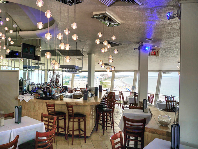 Suspended globe lights create a constellation effect inside Spinners, while floor-to-ceiling windows frame postcard-worthy views that change as you dine.