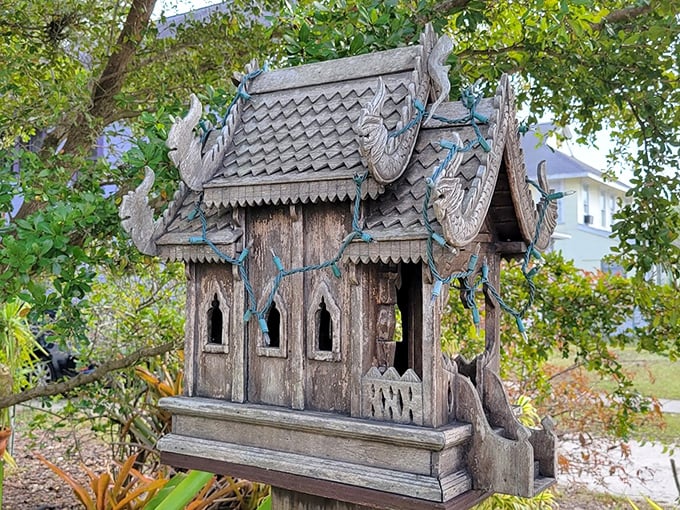Intricate woodwork transforms this spirit house into a miniature temple of creativity, showcasing traditional craftsmanship with a Florida twist.