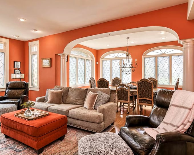 Warm coral walls embrace this elegant living space, where arched windows flood the room with Florida sunshine.