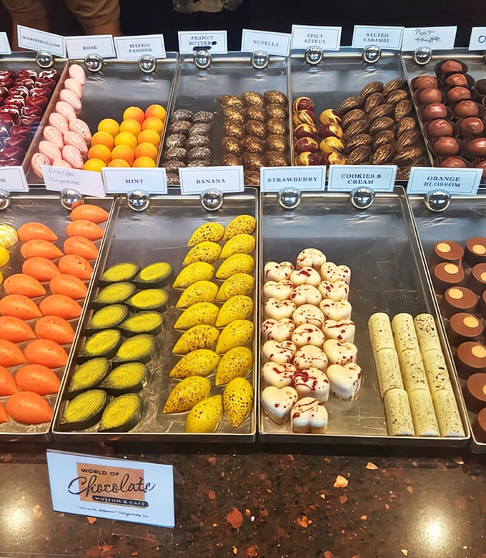Rows of handcrafted bonbons gleam like edible gemstones, each one a tiny flavor explosion waiting to happen.