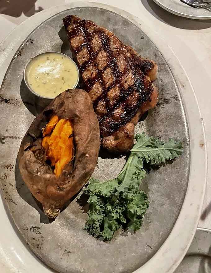 This strip steak showcases the beautiful char and juicy interior that separates great steakhouses from mediocre ones.