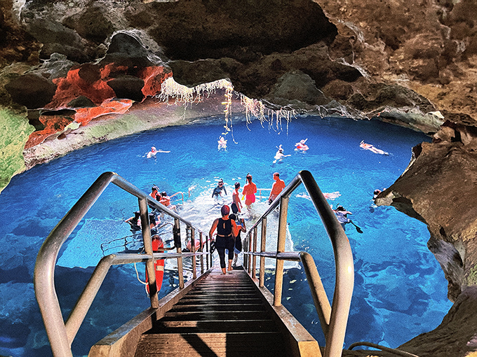 Ancient cathedral: Swimmers enjoy the natural skylight effect as sunbeams pierce through the karst window above.