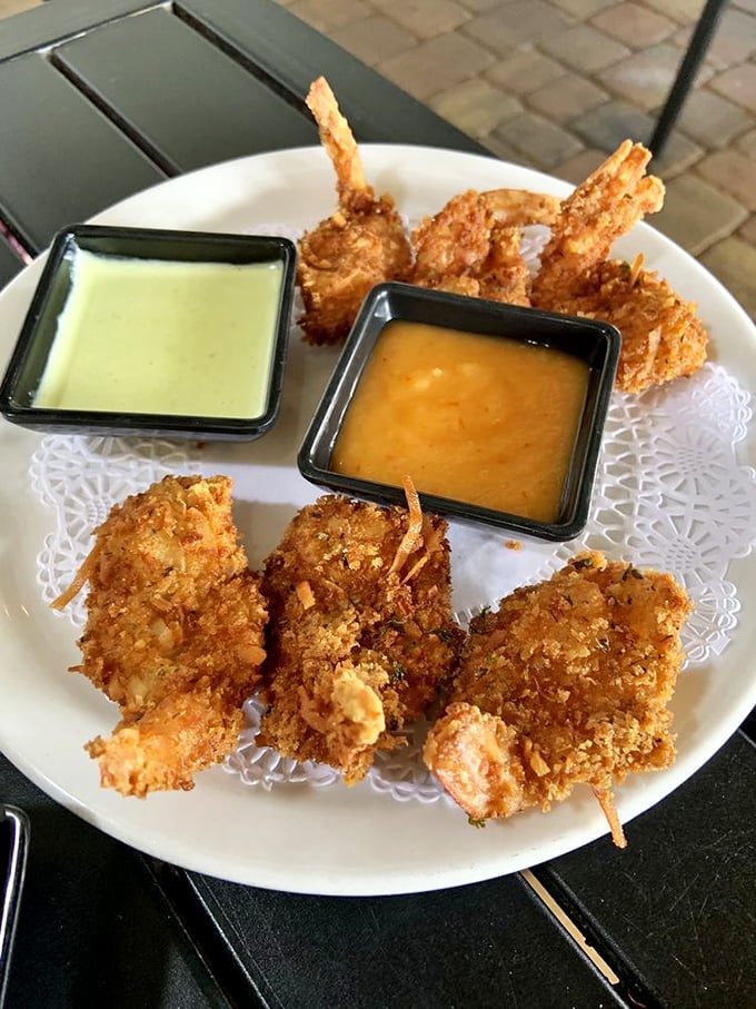 Coconut shrimp arrive golden and crispy, served with dipping sauces that complement the natural sweetness of the seafood with tropical undertones.