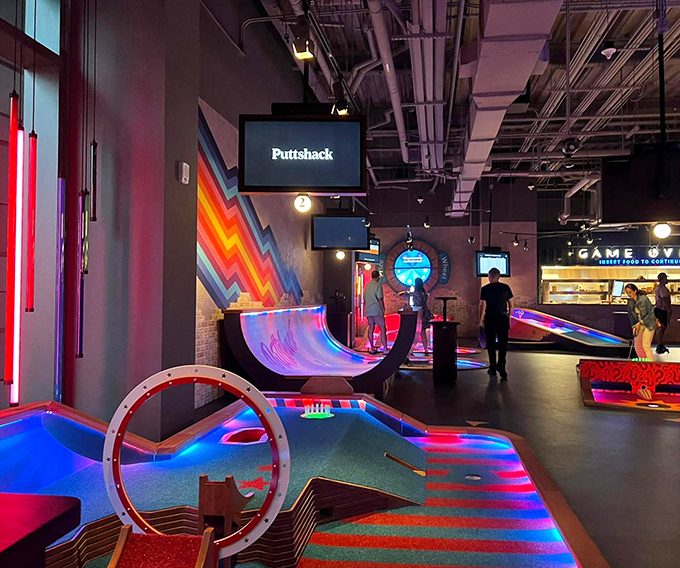 Players navigate courses that blend traditional putting skills with arcade-style challenges. That concentrated look? Pure competitive spirit in action.