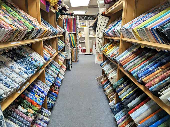 Walking this aisle feels like entering a textile time machine – patterns from every era inviting you to touch, imagine, create.