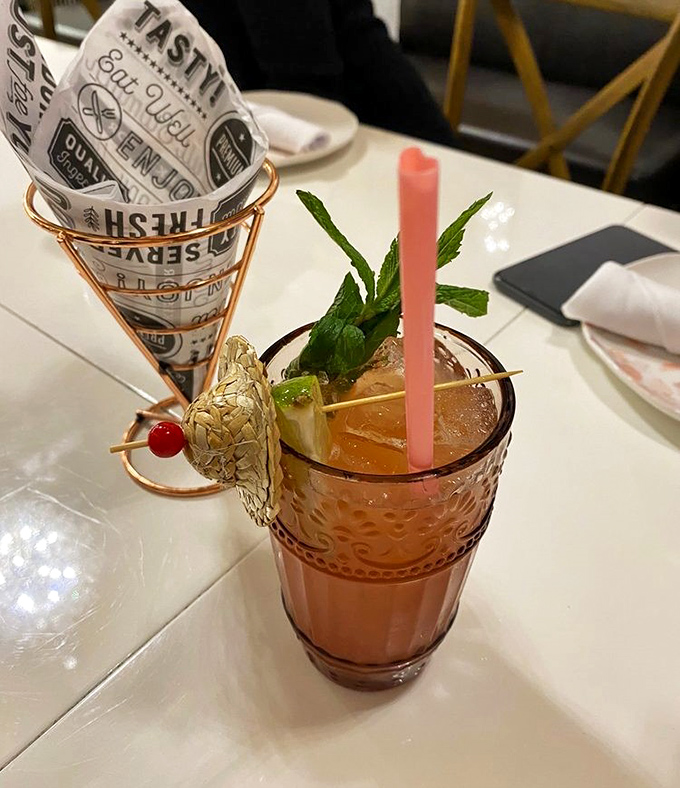 Pretty in pink! This tropical cocktail comes with its own snack sidekick, proving that good things come in small, beautifully garnished packages.