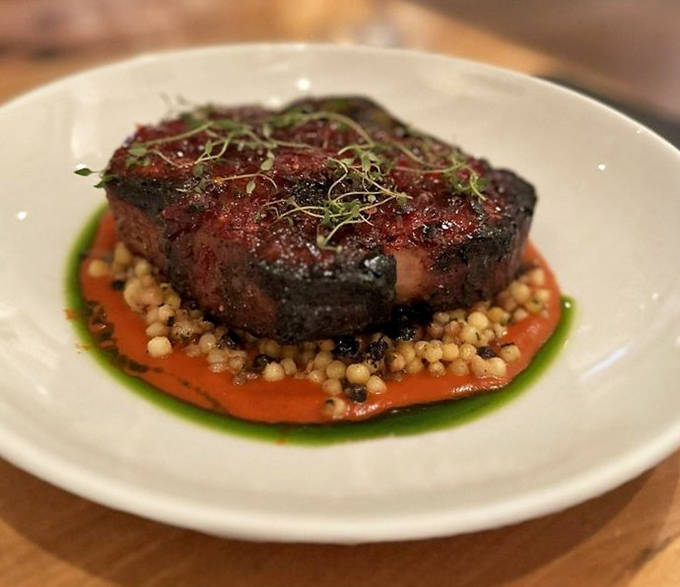 This isn't just pork, it's a masterpiece &ndash; a perfectly seared ribeye resting on colorful accompaniments that make your fork dance with delight.