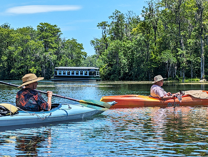 Kayakers enjoy a peaceful paddle while a glass-bottom boat glides by in the distance &ndash; two perfect ways to experience this watery wonderland.