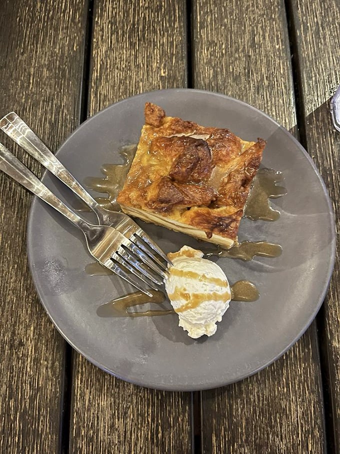 The bread pudding arrives warm and comforting, swimming in a rich sauce that makes each bite a perfect balance of sweetness and texture.