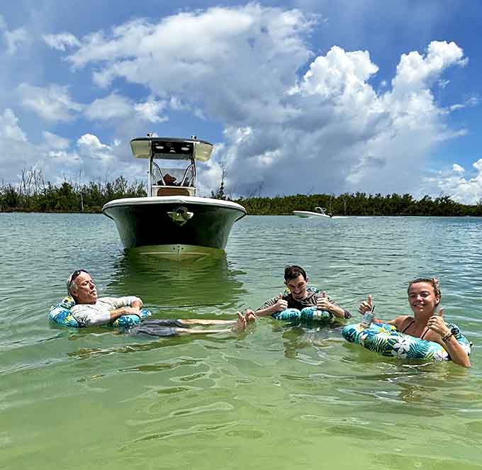 Three people floating with drinks in hand perfectly capture the Keewaydin vibe: relaxed, slightly ridiculous, and absolutely living their best life.