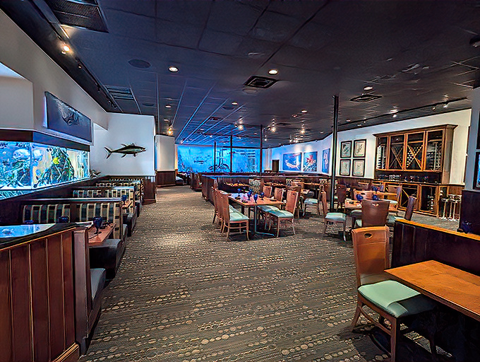 The main dining room where underwater magic meets culinary craft &ndash; those rich wood tones complement the aquatic blue glow perfectly.