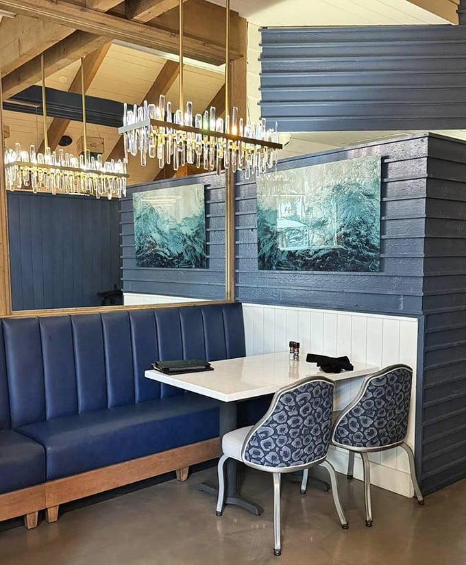 Elegant blue booths and crystal lighting create an unexpected sophistication within the rustic treehouse setting, blending comfort with upscale dining.