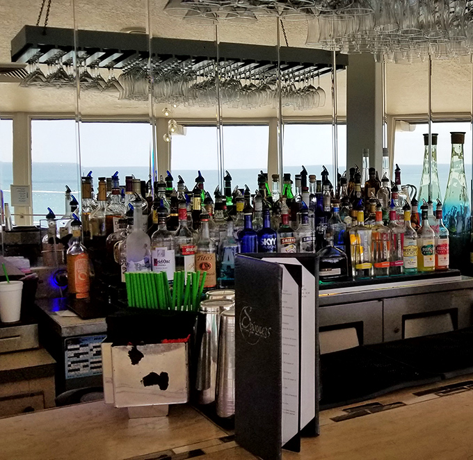 The bar gleams with promise, bottles backlit against Gulf views &ndash; where even waiting for your table becomes part of the experience.