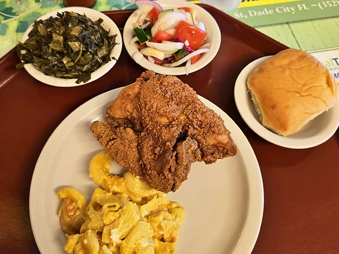 A perfect Southern plate: crispy fried chicken, creamy mac and cheese, collard greens, and a roll to sop up every last bit.