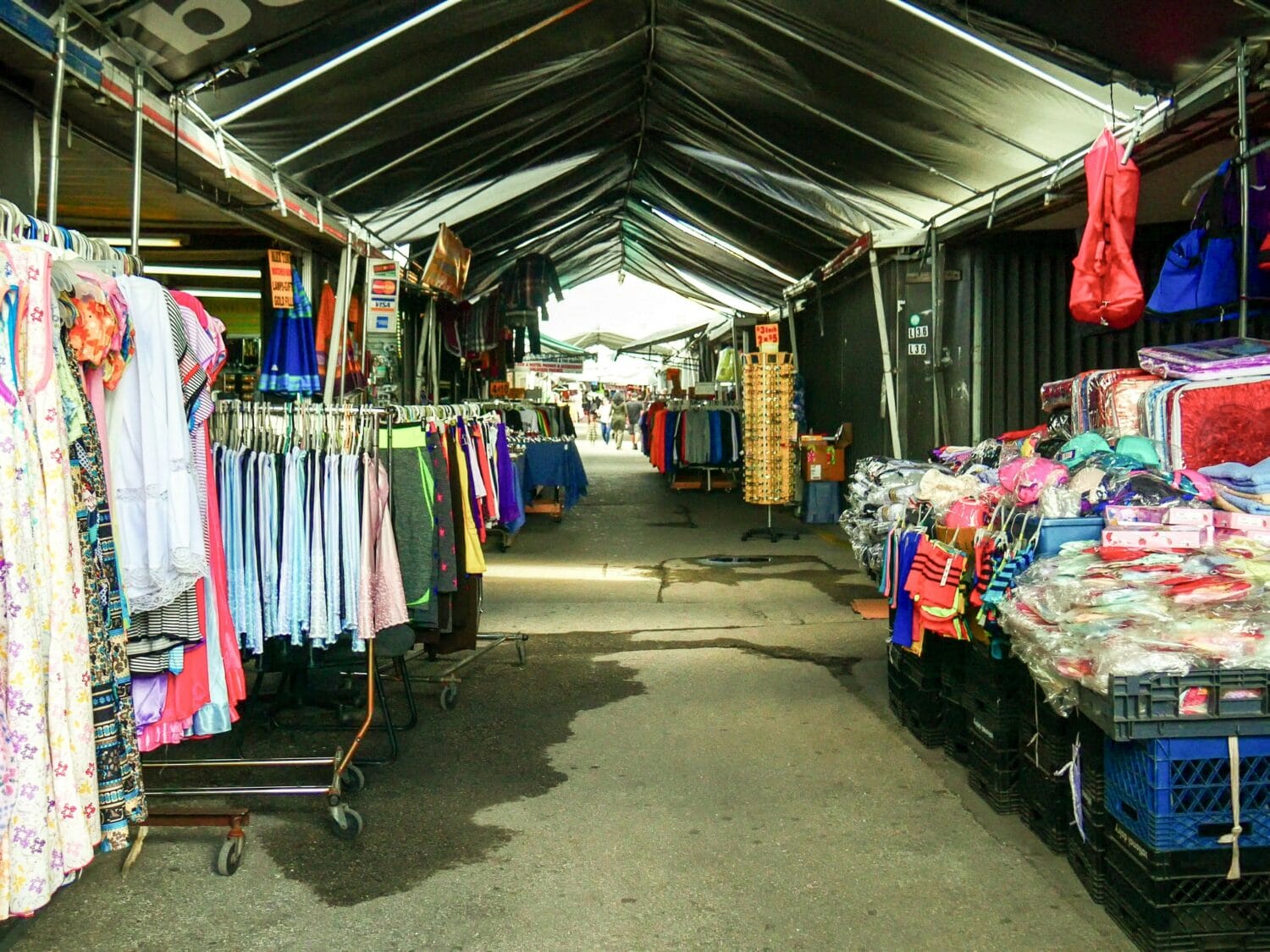 A line of stalls full of clothing racks.
