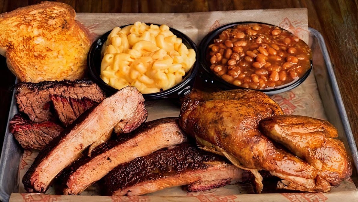 A tray of yummy and succulent BBQ with various side dishes.