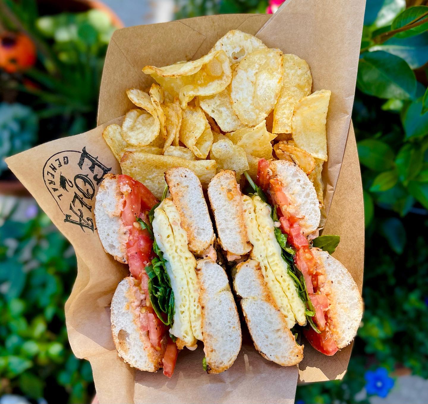 A yummy bagel with chips.