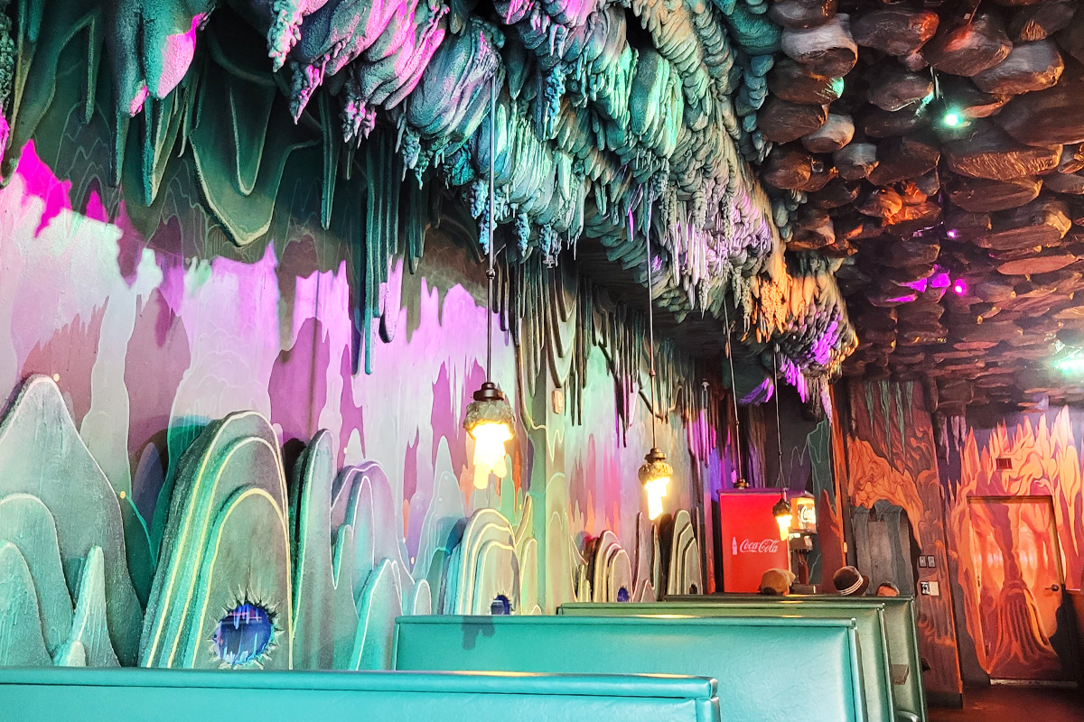 The neon lit cave like interior of the pizzeria.