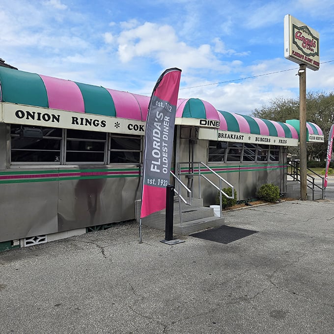 The iconic pink and green striped awning of Florida's oldest diner beckons hungry travelers with promises of classic American comfort food since 1932.