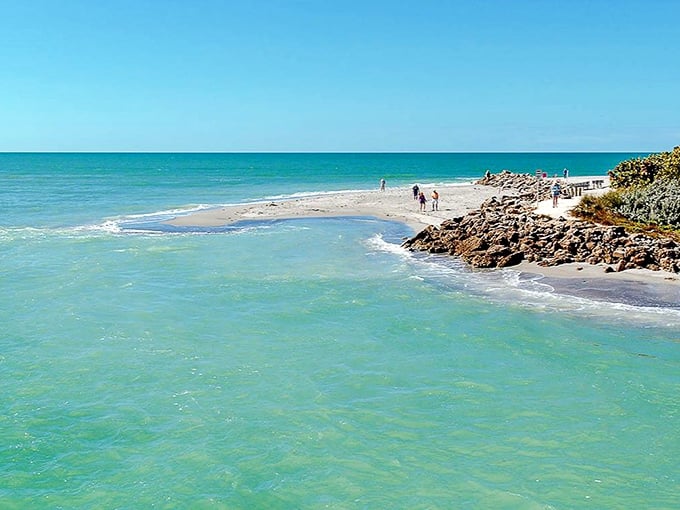 Where two islands meet, nature creates a shell collector's paradise at Blind Pass Beach's turquoise waters.