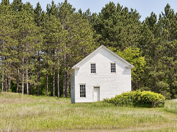 A pristine white house stands sentinel among towering pines, like a page torn from Minnesota's frontier history book.