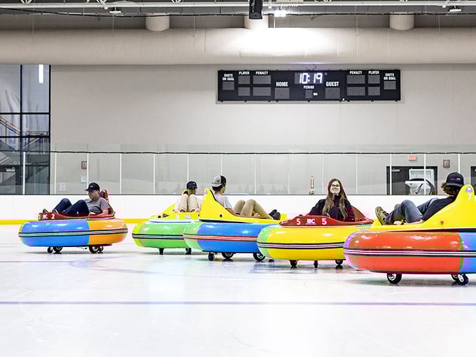 Riders glide and spin across the ice in colorful ice bumper cars, enjoying a playful winter attraction inside an indoor rink in Minnesota.