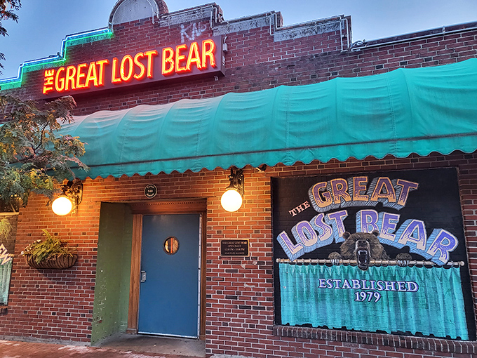 The iconic neon sign of The Great Lost Bear glows against the brick facade, beckoning hungry patrons like a lighthouse for comfort food enthusiasts.