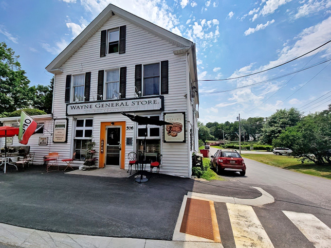 The classic white clapboard exterior of Wayne General Store stands proudly on Main Street, a time capsule of small-town Americana with modern culinary treasures inside.