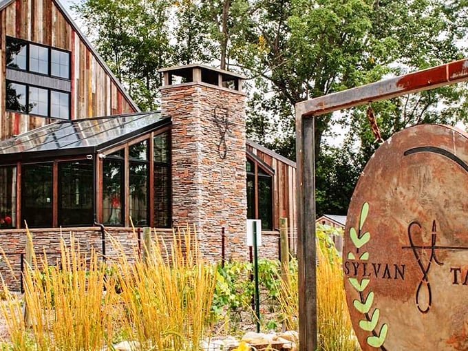 A centuries-old barn finds new purpose as Sylvan Table, where weathered wood and stone create an entrance that practically whispers "come in and stay awhile."