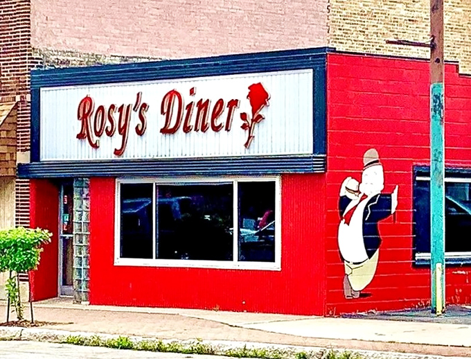 The vibrant red exterior of Rosy's Diner stands out like a culinary beacon in Escanaba, promising homestyle comfort that delivers beyond its modest size.