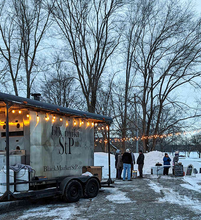 String lights twinkle above the Black Market StP trailer as eager customers brave the Minnesota winter for barbecue worth the wait.