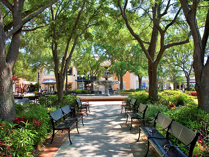 Hyde Park Village's central plaza invites visitors to pause and soak in the Florida sunshine, where dappled light plays through ancient oaks like nature's own spotlight.